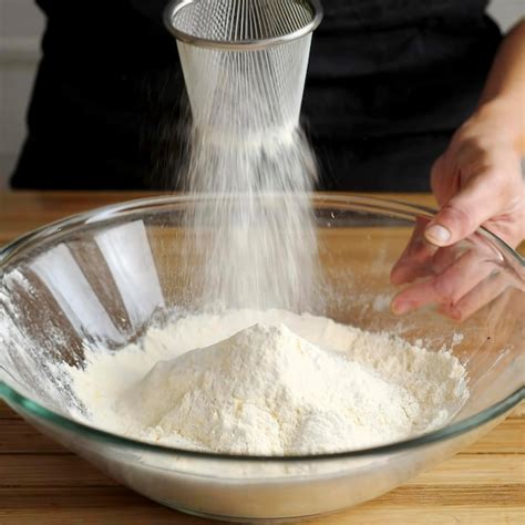 Premium Photo Sifting Flour Through A Sieve Into A Large Glass Bowl
