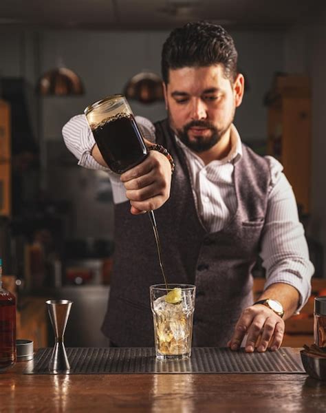 Premium Photo Bartender Pouring Craft Cocktail At Bar