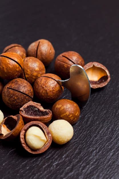 Premium Photo Whole And Open Macadamia Nuts With Key On Black Background Kernels Of Macadamia