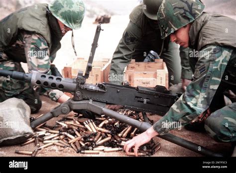 Security Policemen Pick Up Brass Shell Casings After Firing An M 2 50