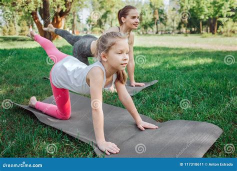 Two Girls Are Excercising In Park Woman Is Sitting On Her Knees And