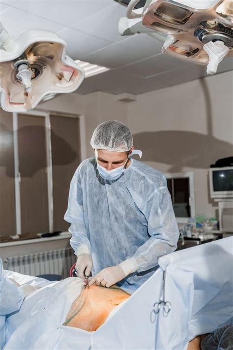 surgeon removes fat in the gluteal region abdominoplasty plastic