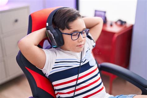 Adorable Hispanic Boy Streamer Relaxed With Hands On Head At Gaming