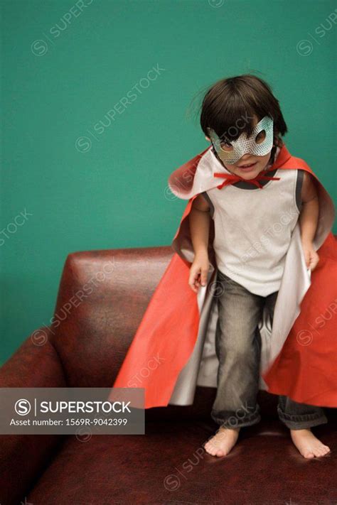 Boy In Costume Standing On Sofa Superstock