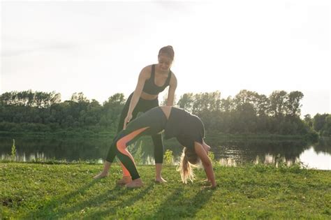 Premium Photo Female Friends Enjoying Relaxing Yoga Outdoors In The Park