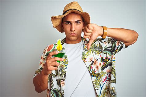 젊은 잘생긴 남자는 화가 얼굴 아래로 엄지 손가락 거부 개념과 싫어하는 보여주는 부정적인 기호와 흰색 고립 된 배경을 통해