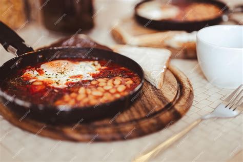 Premium Photo Warm Breakfast Shakshuka With Egg And Beans Bread And Toast