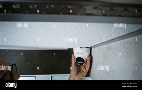 Professional Male Installer Screws Cctv Camera To The Ceiling In Office
