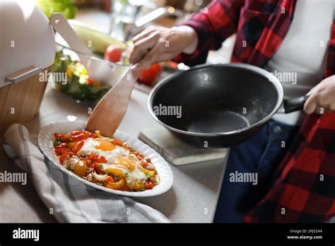 Eine Frau Die Frisch Gebratene Eier Mit Gemüse Auf Den Teller In Der