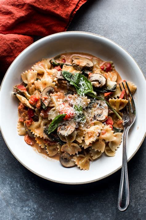Farfalle Pasta With Mushrooms And Spinach In A Creamy Tomato Sauce