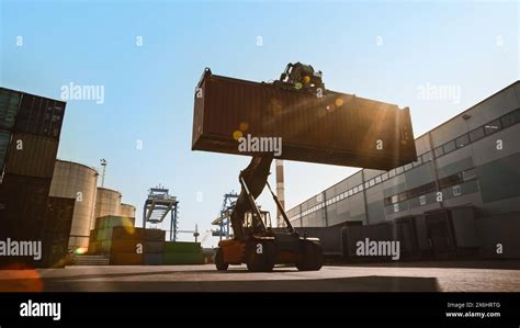 Modern Container Handler Carrying A Large Red Steel Shipping Cargo Storage Container In A