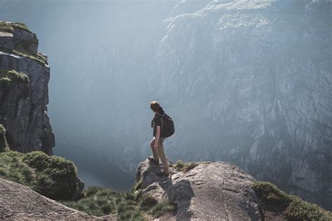 Premium Photo Hiker Standing On The Edge Of A Cliff And Enjoying The