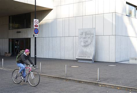 Bicycle Driver Passes The Sculpture Of Stanislaw Lem Located Next To The Library Building Of