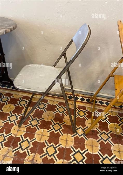 Two Metal Folding Chairs And A Small Metal Table Set Up In An Outdoor