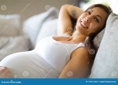 Pretty Pregnant Woman Lying on the Sofa with Her Hand at Belly Stock Photo - Image of depression ...