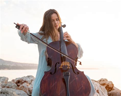 Músico Tocando El Violonchelo Al Aire Libre Foto Gratis