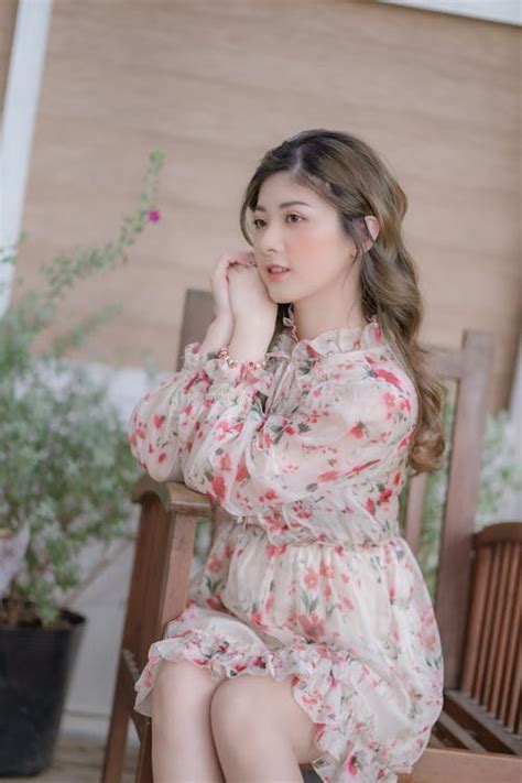 Beautiful Young Woman In A Floral Dress Sitting On A Chair · Free Stock