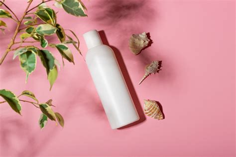 조개와 그림자가 있는 분홍색 배경에 얼굴 크림이나 로션 텔라나를 곁들인 화이트 코스메틱 보틀 선 크림 여름 화장품 배경 주제에 대한 스톡 사진 및 기타 이미지 Istock