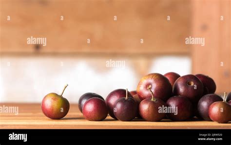 Close Up Of Governors Plum Fruits On Wooden Table Top Flacourtia