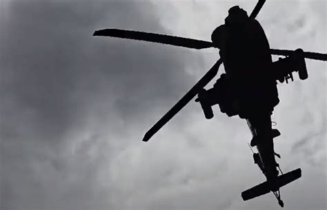 Apache Gunship Roars Overhead In Low Pass Over Village