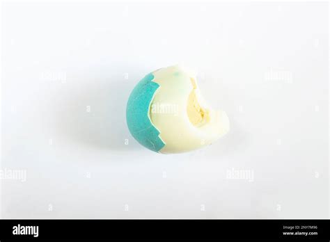 A Bite Of A Boiled Egg In The Shell Lies On A White Background Stock