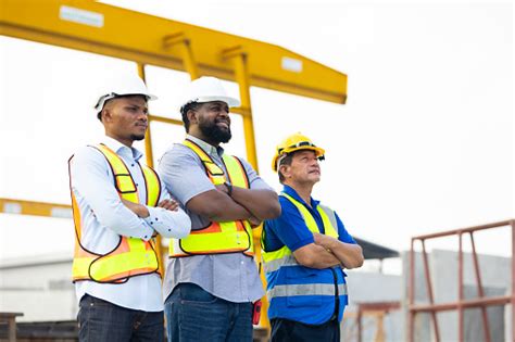 화합과 팀워크 개념 전문 기계 엔지니어 팀 건설 건물용 프리캐스트 철근 콘크리트 벽 패널 공장에서 작업 다민족 그룹에 대한 스톡