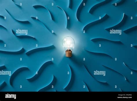 Light Bulb Glowing On A Blue Paper Background The Concept Of Spreading