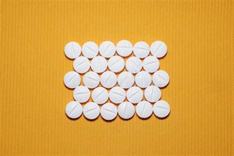 Lots Of White Smooth Convex Tablets With Dividing Strip On Yellow