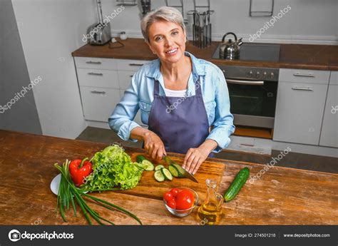 Mature Woman Cooking In Kitchen Stock Photo By Serezniy 274501218