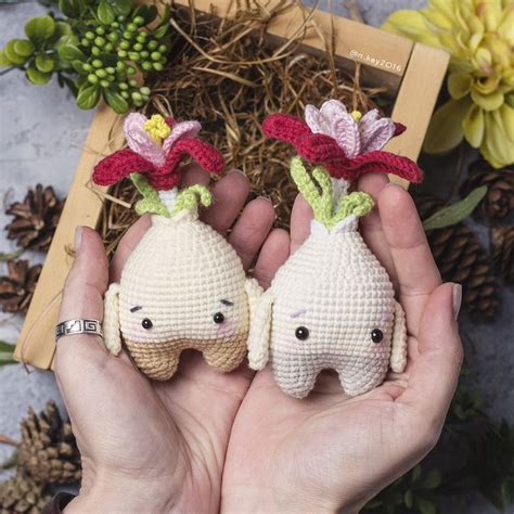 two crocheted stuffed animals are held in their hands with pine cones ...
