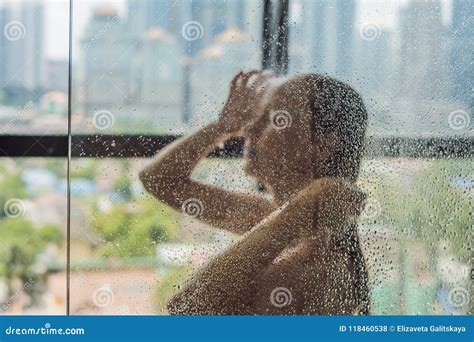 Beautiful Woman In The Shower Behind Glass With Drops On The Background
