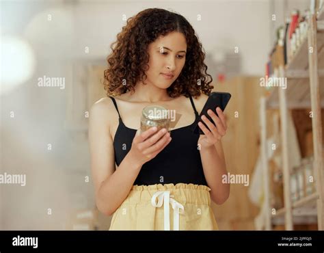 Customer Shopping Browsing Phone And Picking Supermarket Product