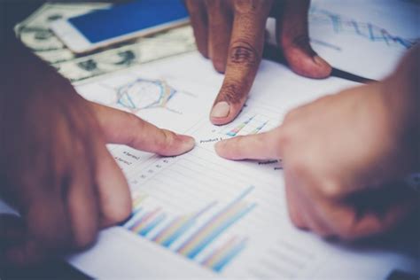 Premium Photo Cropped Image Of Colleagues Analyzing Charts On Table