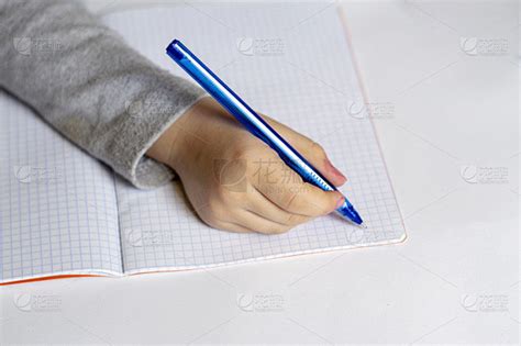 孩子们用圆珠笔在笔记本上写字。