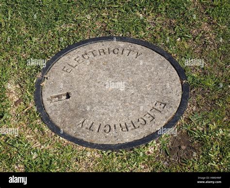Round Concrete Lid On A Electrical Pit On A Nature Strip Marked With