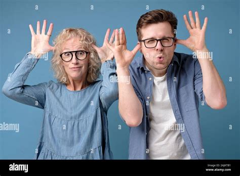 Mature Caucasian Couplemother And Son Teasing Each Other On Blue Background Studio Shot Stock