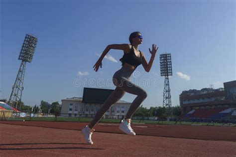 La Atleta Corre En Una Cinta De Correr En El Estadio A Los Rayos Del