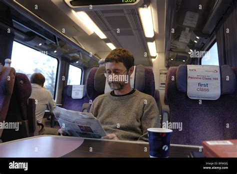 Passenger Reading A Newspaper In A First Class Carriage On A Train In