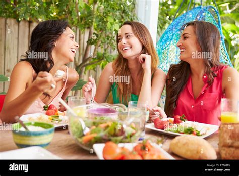 Three Female Friends Enjoying Meal Outdoors At Home Stock Photo Alamy