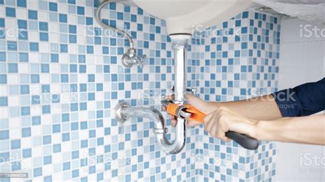 화장실에서 일하는 배관공 배관 수리 서비스 조정 가능한 렌치로 누출 된 싱크대를 수리하고 조립 하고 개념을 설치합니다 화장실 건축물에 대한 스톡 사진 및 기타 이미지