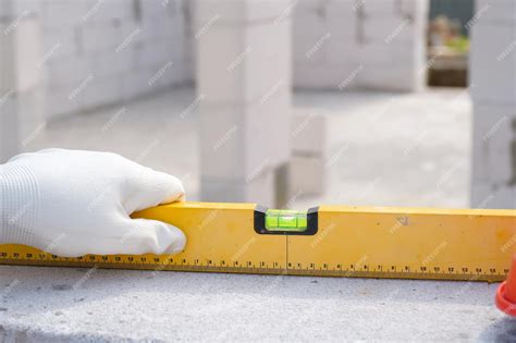 Premium Photo The Hand Of The Builder Measures The Level Of The Plane