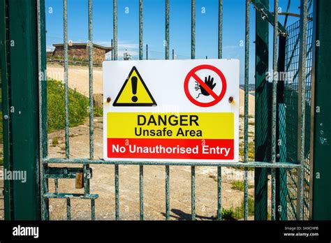 Danger Unsafe Area No Unauthorized Entry Sign On Gated Fence Hythe