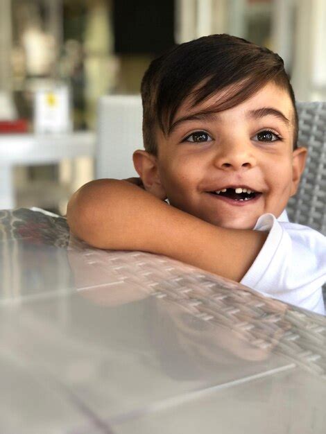 Premium Photo Close Up Of Gap Toothed Boy Sitting At Dining Table