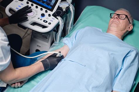 Senior Man Undergoing Vascular Ultrasound Examination In Clinic Stock