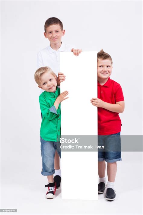 흰색 배경에 웃고 있는 세 명의 젊은 학생들이 수직으로 흰색 포스터를 들고 카메라를 바라보고 있었다 경영자에 대한 스톡 사진 및 기타 이미지 Istock