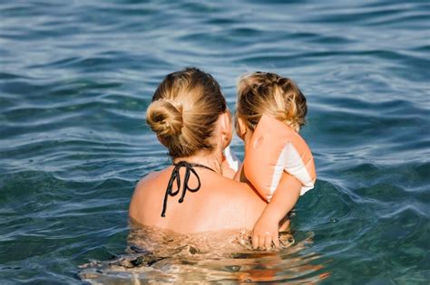 Premium Photo Rear View Of Mother With Daughter In Sea