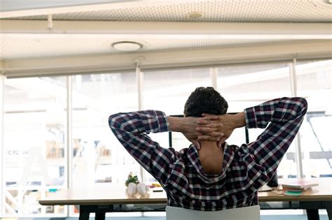 Premium Photo Male Graphic Designer With Hands Behind Head Sitting On