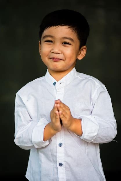Premium Photo Portrait Of Cute Smiling Boy In Prayer Position Against