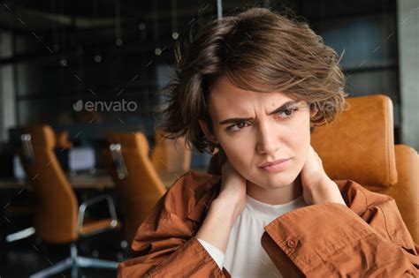 Portrait Of Woman Touching Her Neck Massaging Her Tensed Muscles