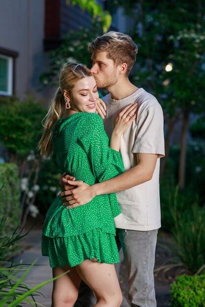 Foto Vertical De Un Joven Besando A Su Novia Foto Premium